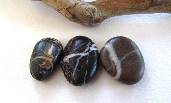 Black brown rocks. Smooth striped stones. Beach pebbles for