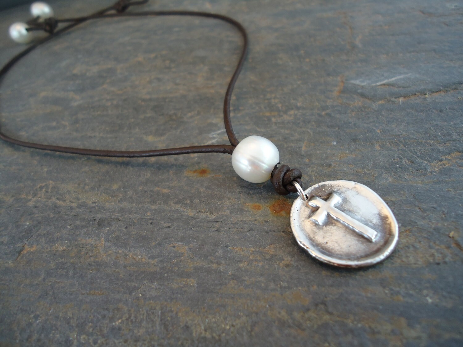 Sterling silver stamped cross on pearl and leather