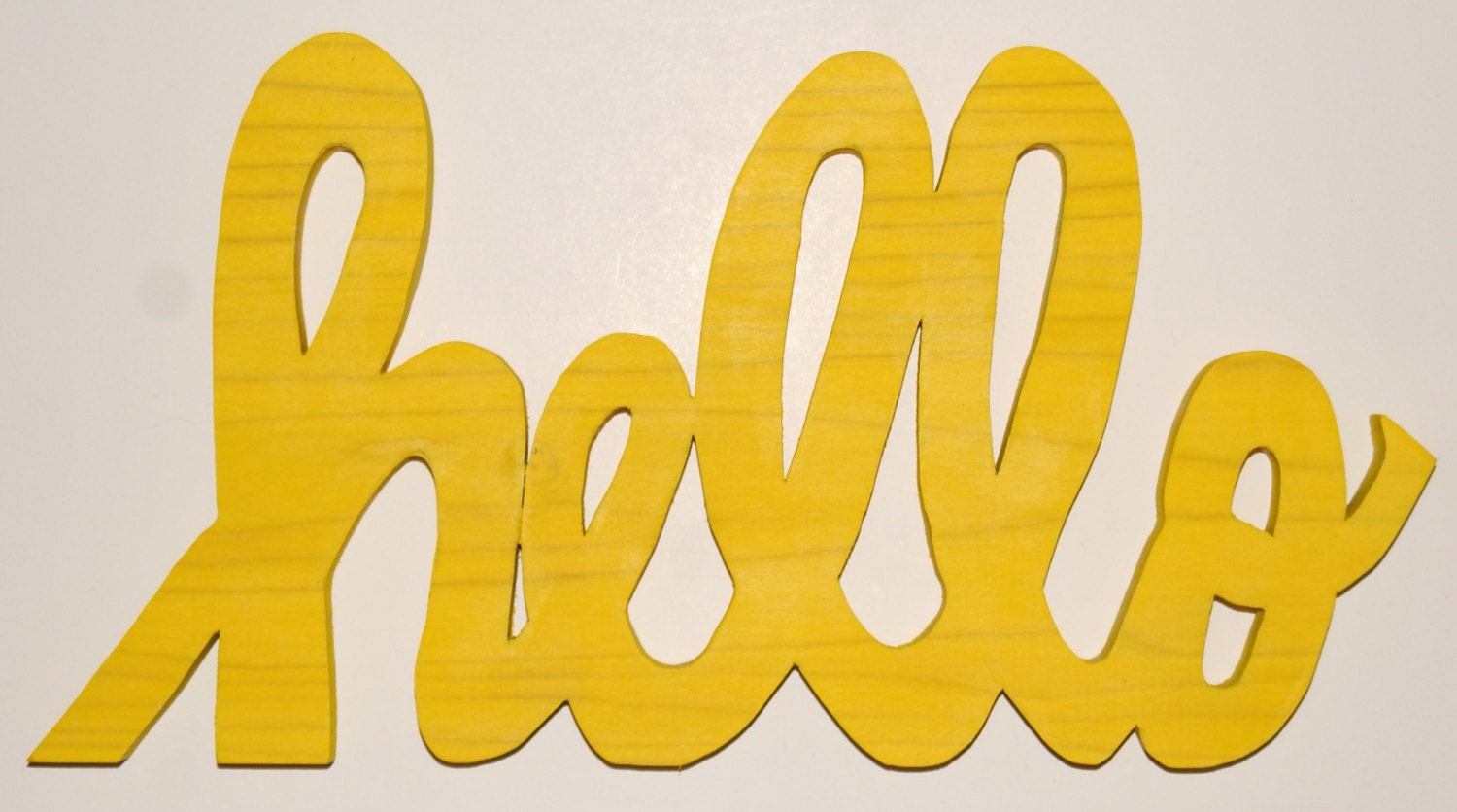 Hello wooden sign painted yellow cursive text about