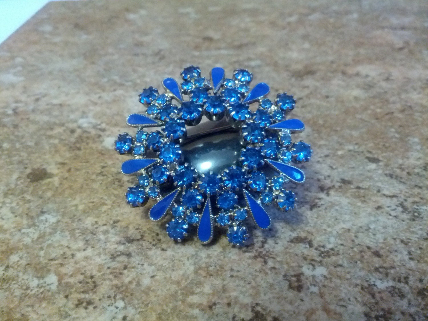 Lovely circular brooch with a spray of Blue shiny rhinestones and ...