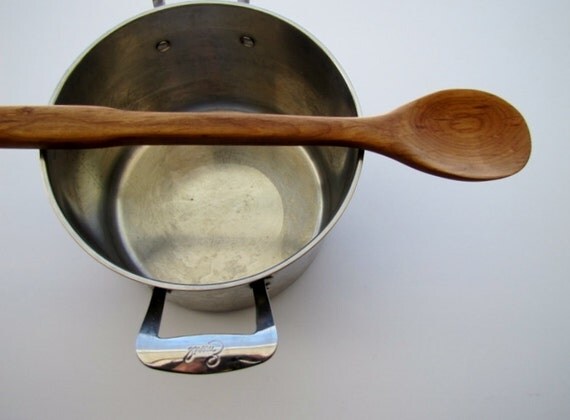 A large hand carved wooden stock pot spoon for kitchen food