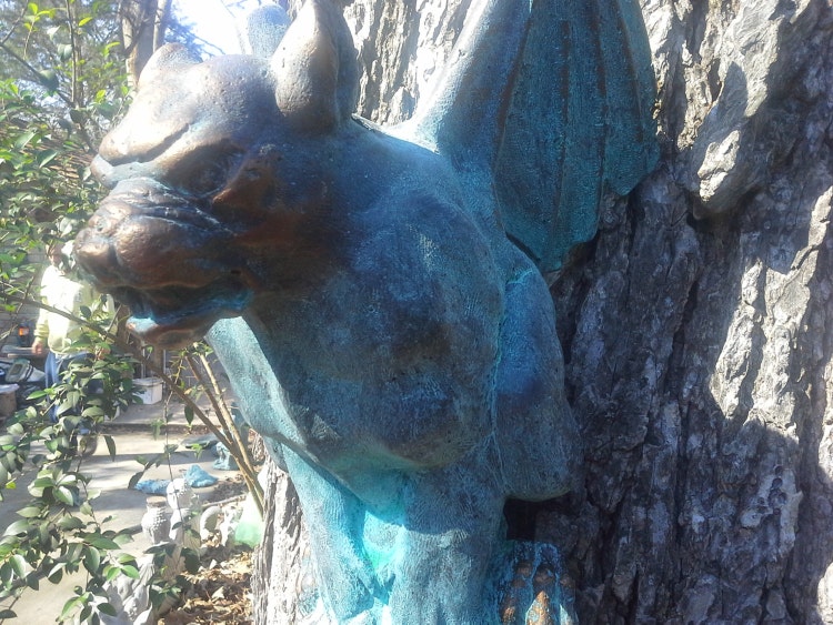 Gargoyle coming out of the tree wall fence gate by GableGargoyles