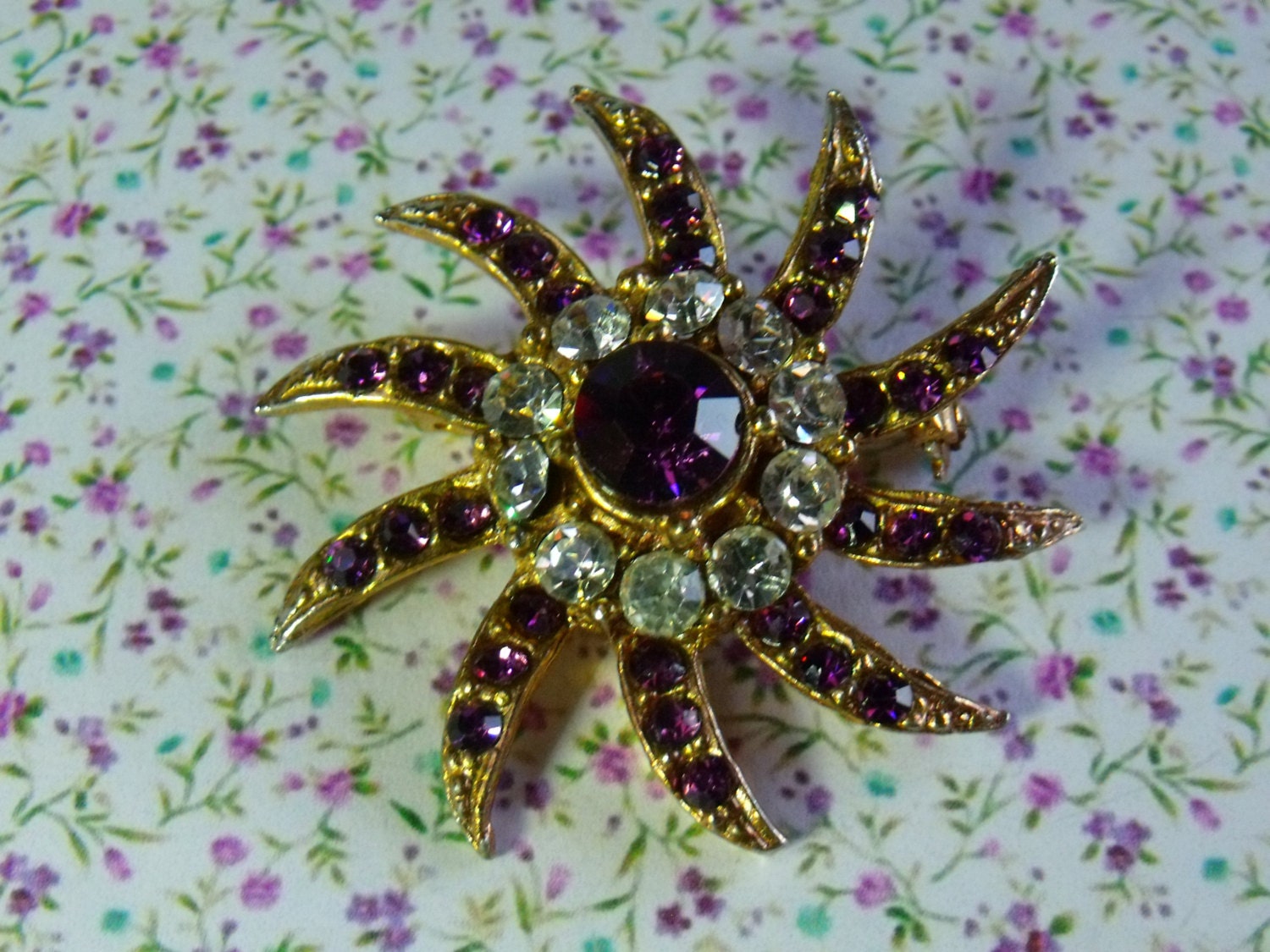 A superb vintage round brooch in goldtone metal set with deep rich ...