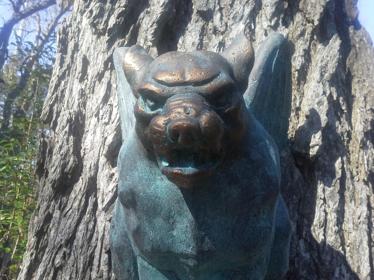 Gargoyle coming out of the tree wall fence gate by GableGargoyles