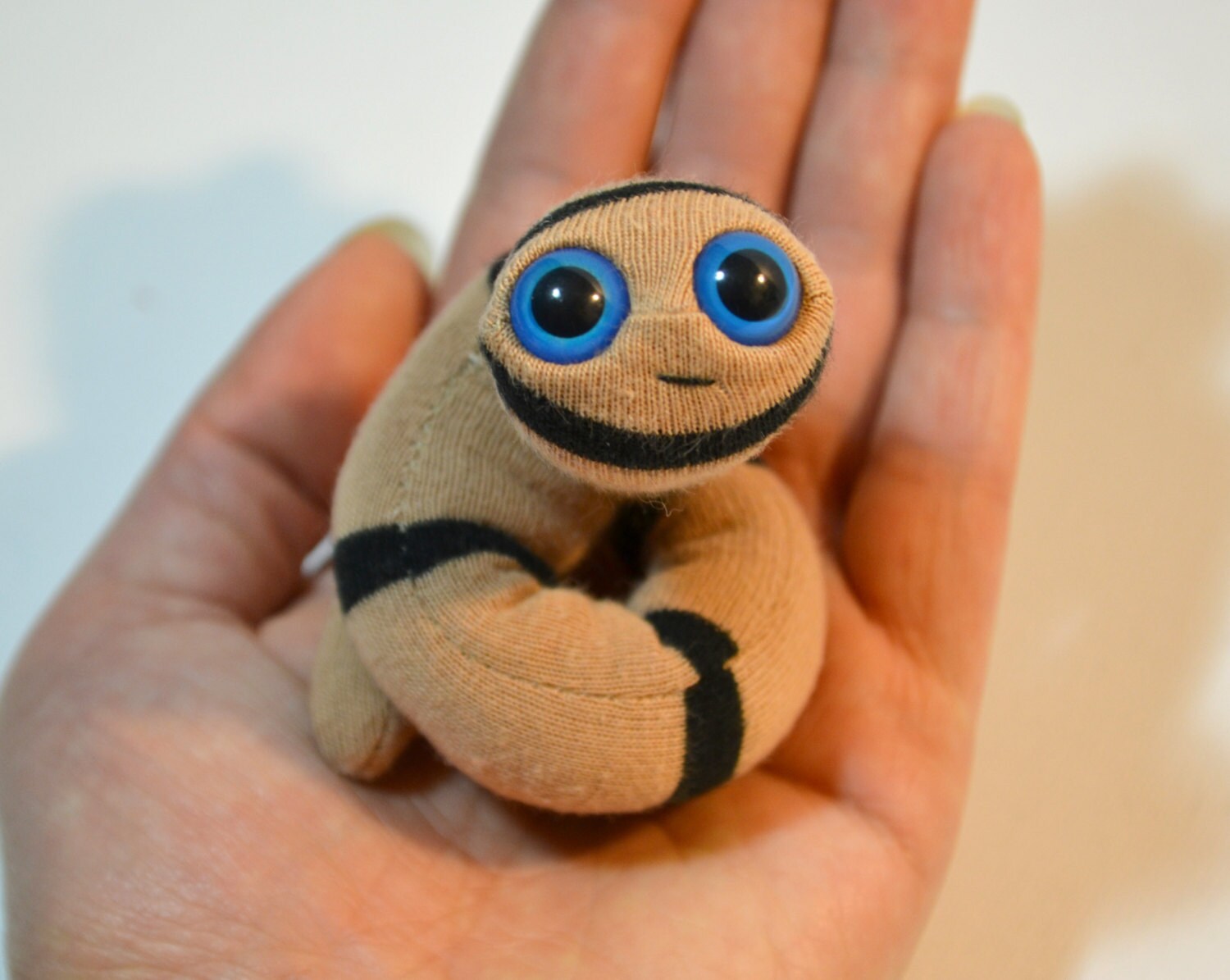Pocket Worm puppet beige black stripes blue eyes