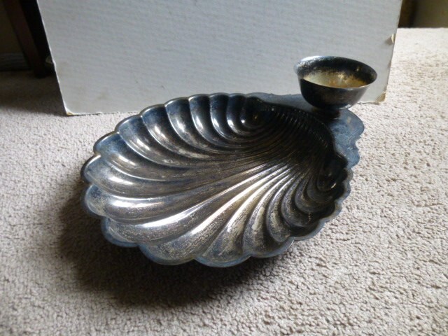 She sells seashell shaped silverplate serving stuff at the sea shore ...