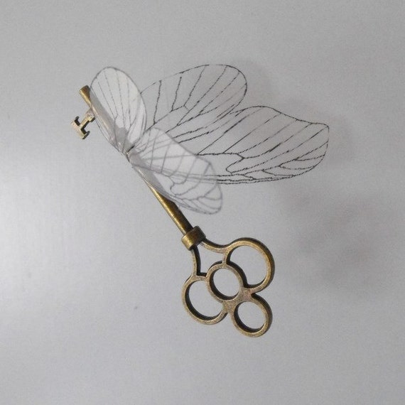 Winged flying key with large reversed wings in antique brass