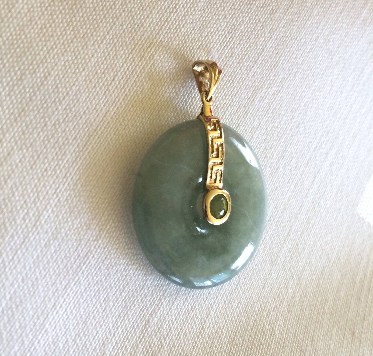 Lovely Green Jade Round Pendant. Piece has a peridot accent stone w/ 14 ...