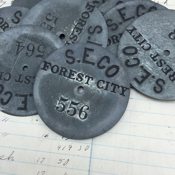 Antique numbered round silver metal tags forest city