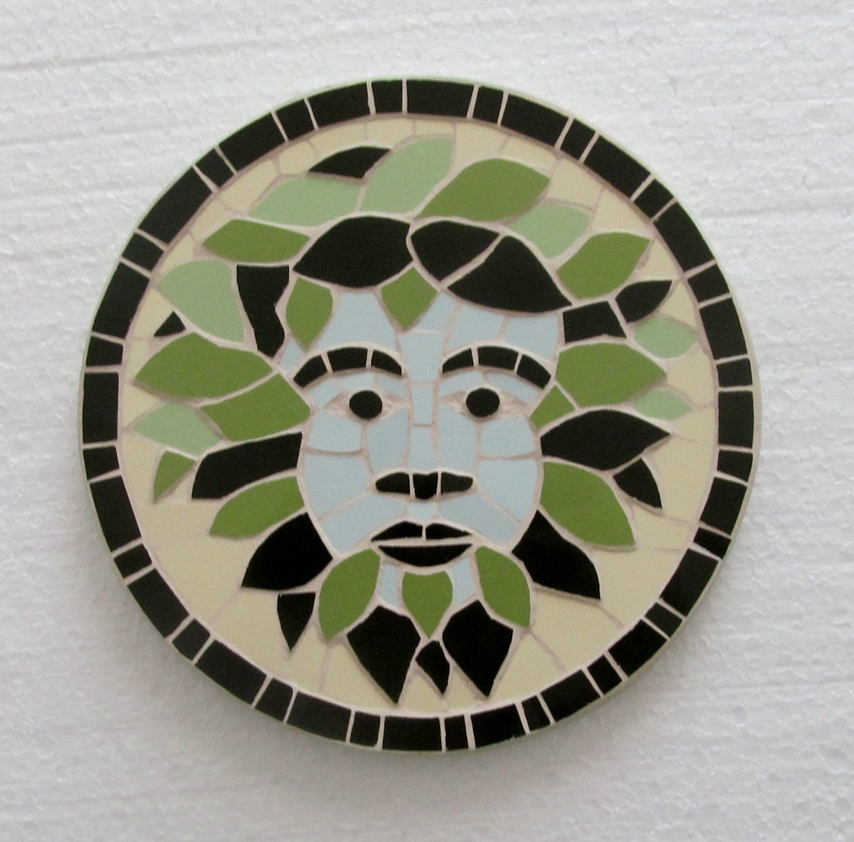 Mosaic of the 'Green Man' in ceramic tiles garden