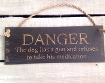funny sign. danger the dog has a gun and refuses to take his medication ...