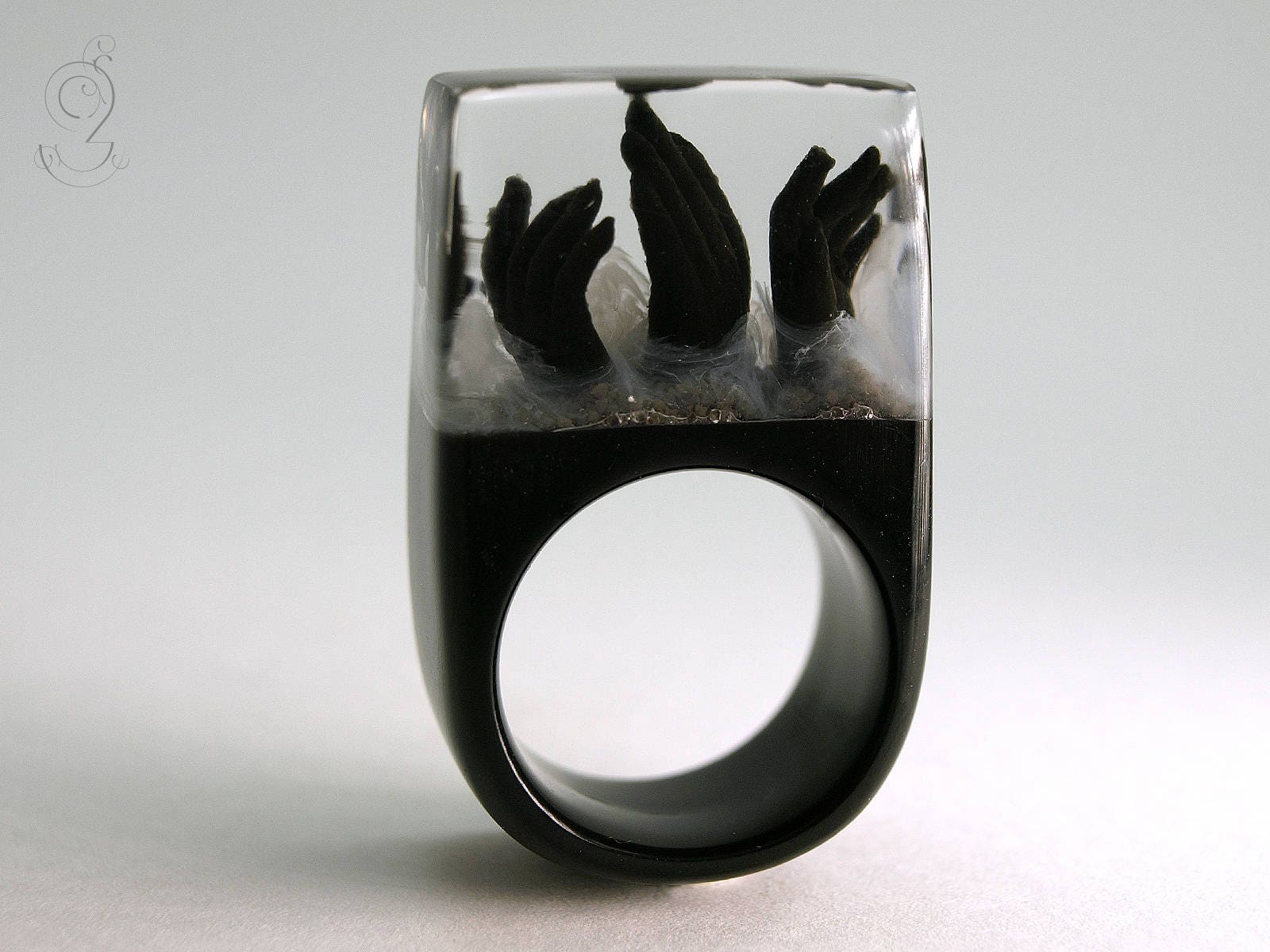 Zombie creepy undead ring with three black hands and fog on