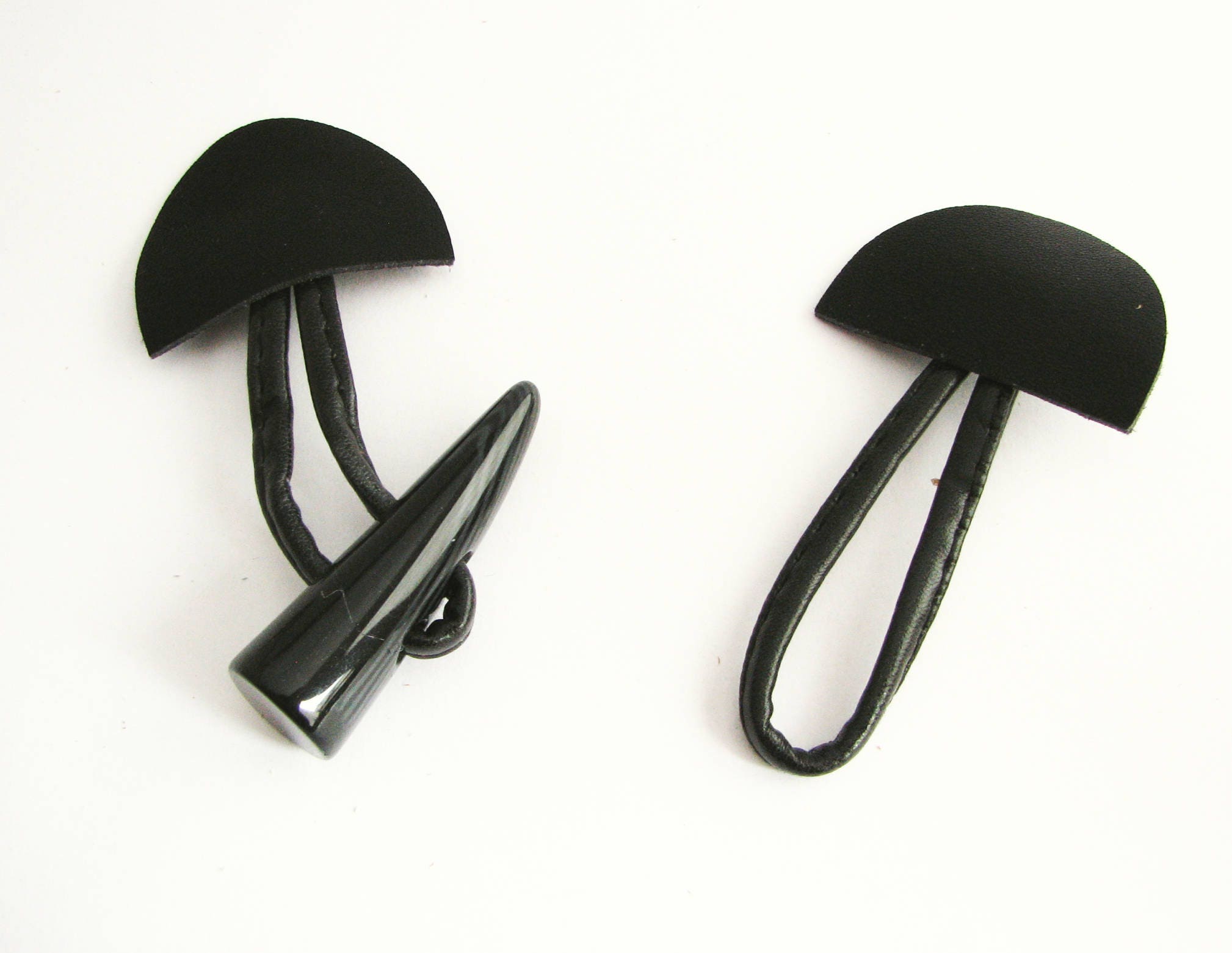 2 black toggle buttons, large leather toggles with loops, A pair of ...
